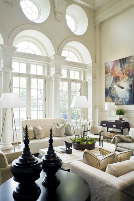 Glamorous living room with high ceiling and tall white floor lamps. The ...